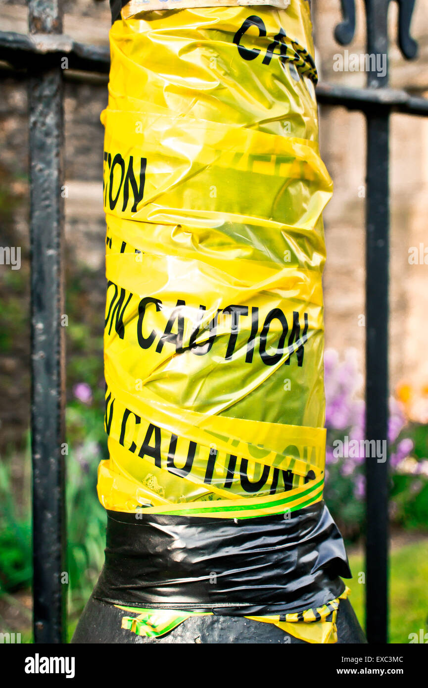 Yellow tipe wrapped round a lamp post warning of danger Stock Photo - Alamy