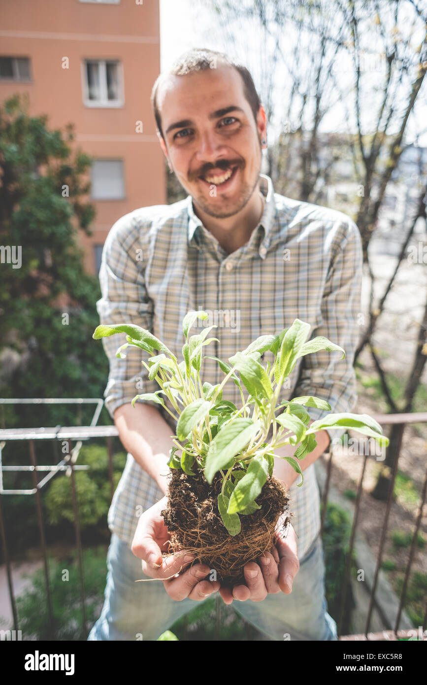 handsome stylish man holding basil plant at home Stock Photo - Alamy