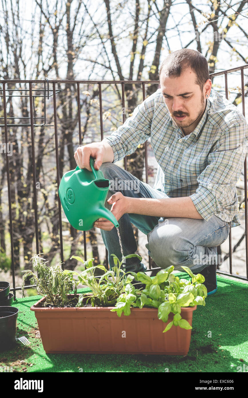 handsome stylish man gardening and watering at home Stock Photo - Alamy