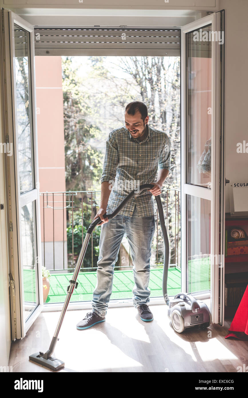 handsome stylish man using hoover at home Stock Photo - Alamy