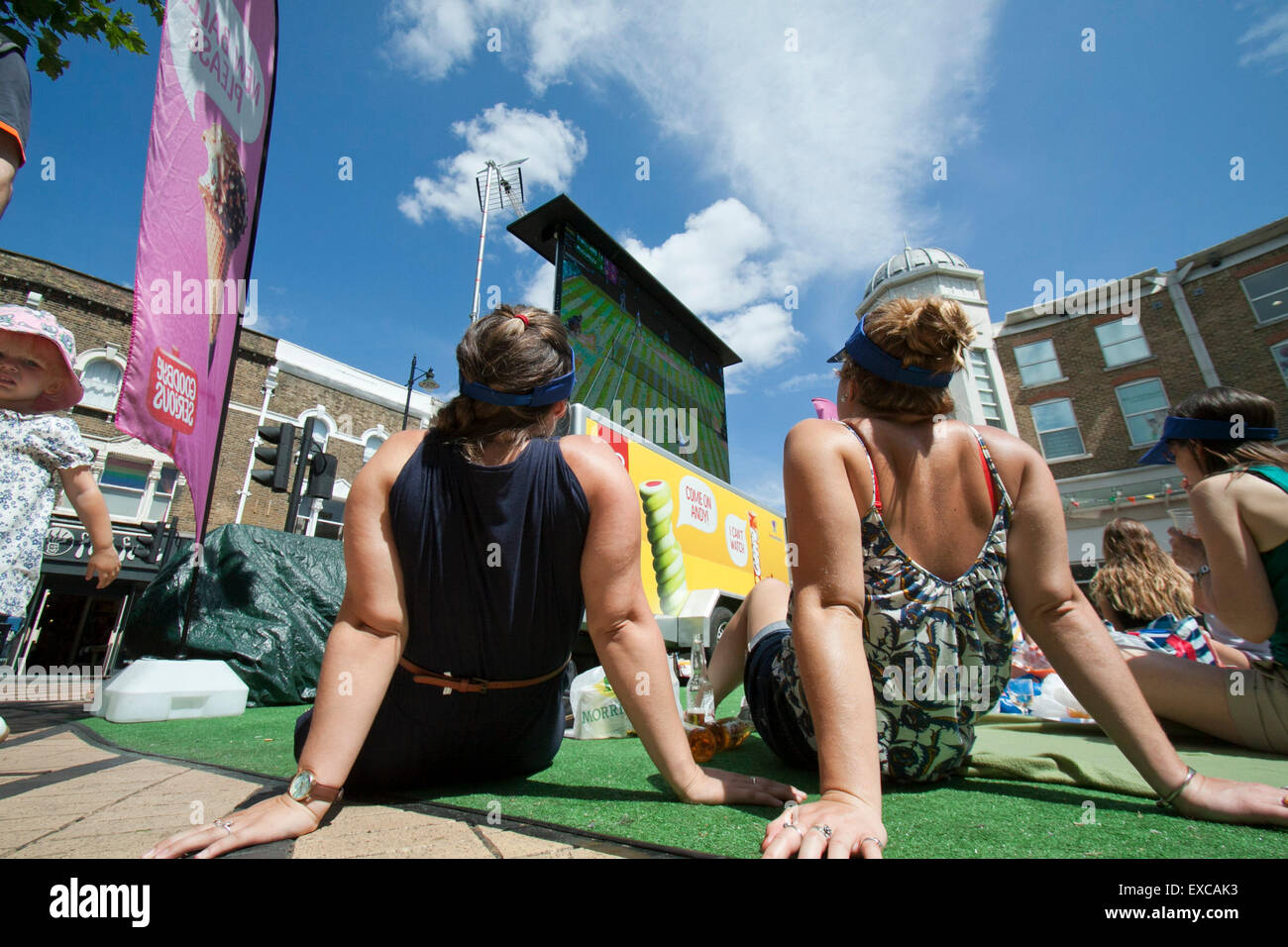 Wimbledon London,UK. 11th July 2015. People sit outside to watch the ...