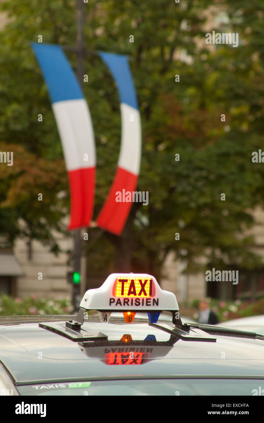 Taxi sign and its reflection on a roof of a taxicab with flags of ...