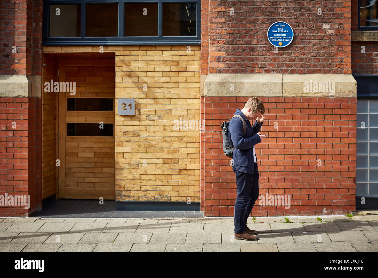 The old Boardwalk nightclub in Manchester UK a man passes stops to text ...