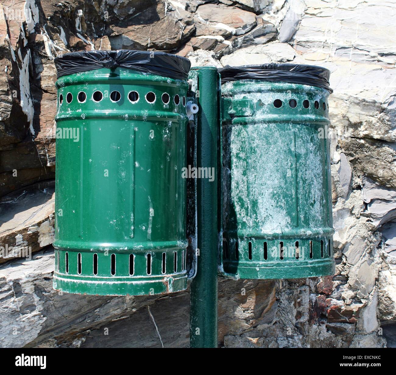 Pair of bins for waste, metal, green color. In the background the rock ...