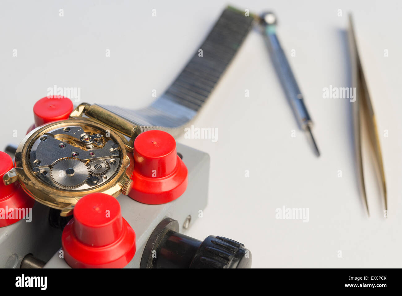 watch with back removed and the movement on show held in a watchmakers ...