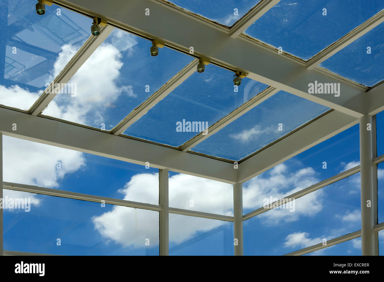 Dirty, watermarked building glass panels against blue sky and white ...