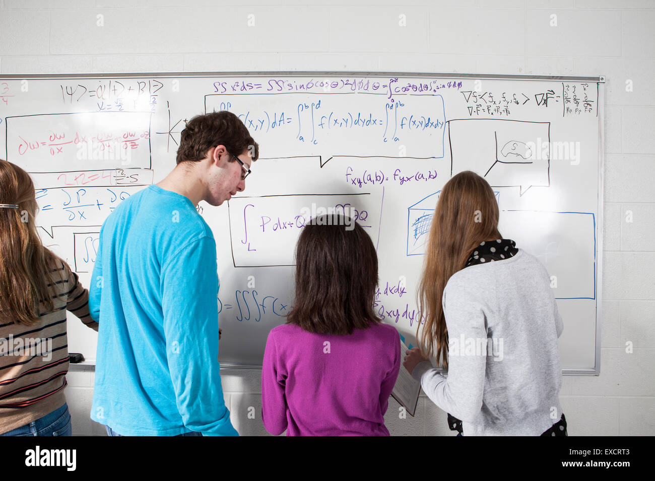 High school students work on equations on a classroom white dry erase ...