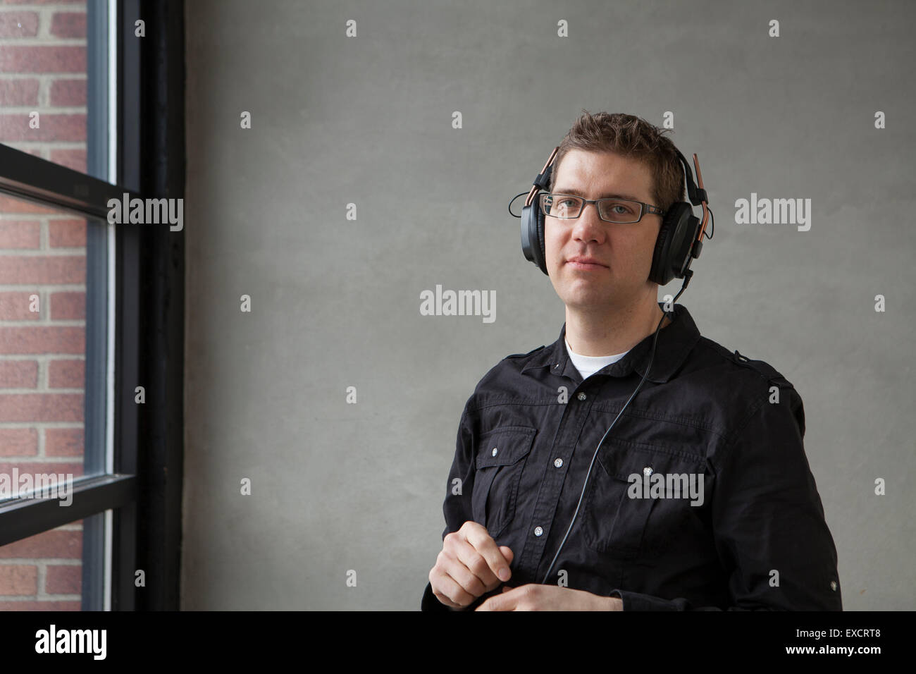 A studio portrait of a stylish hipster DJ wearing his headphones Stock ...