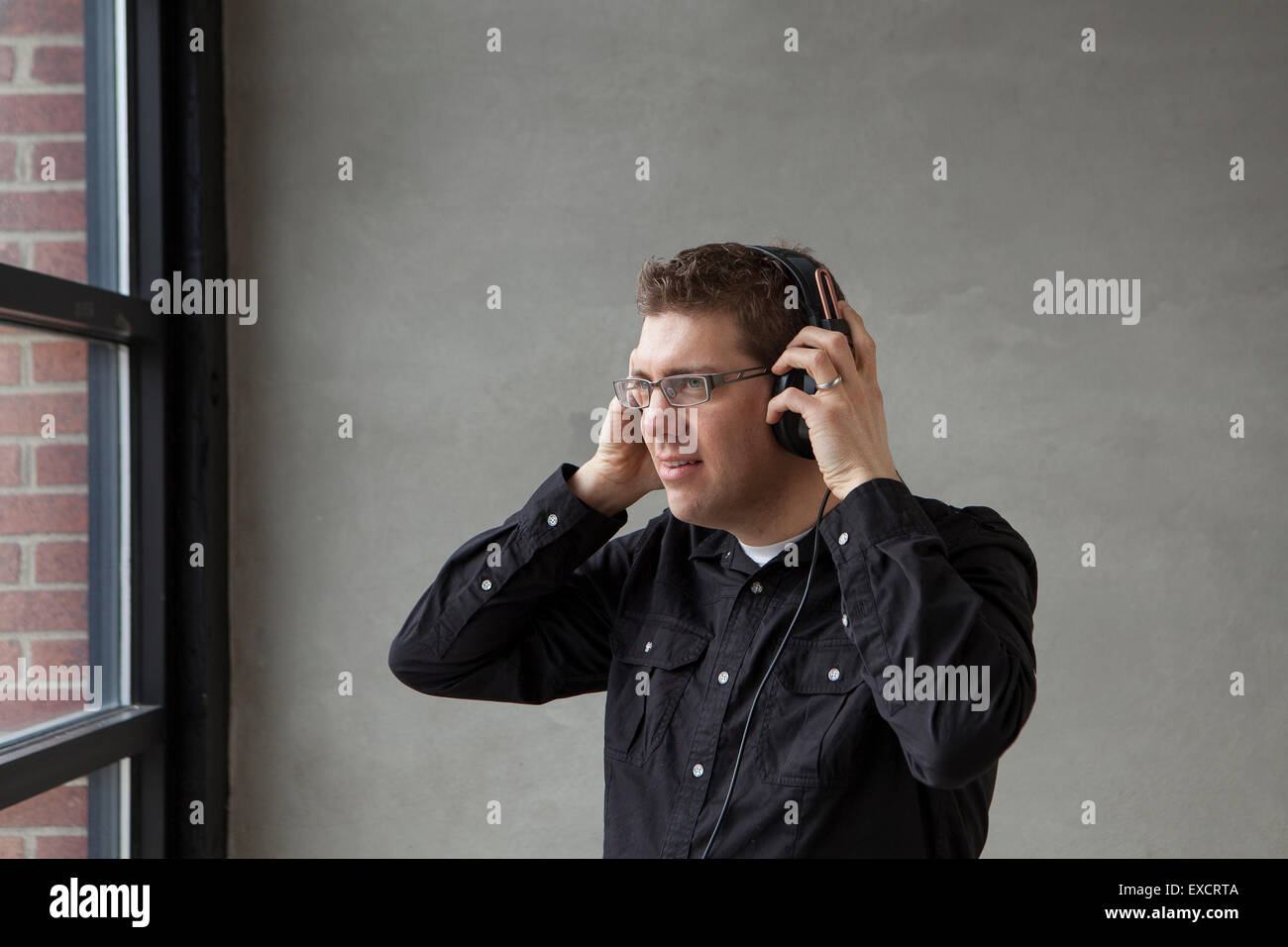A studio portrait of a stylish hipster DJ wearing his headphones Stock ...