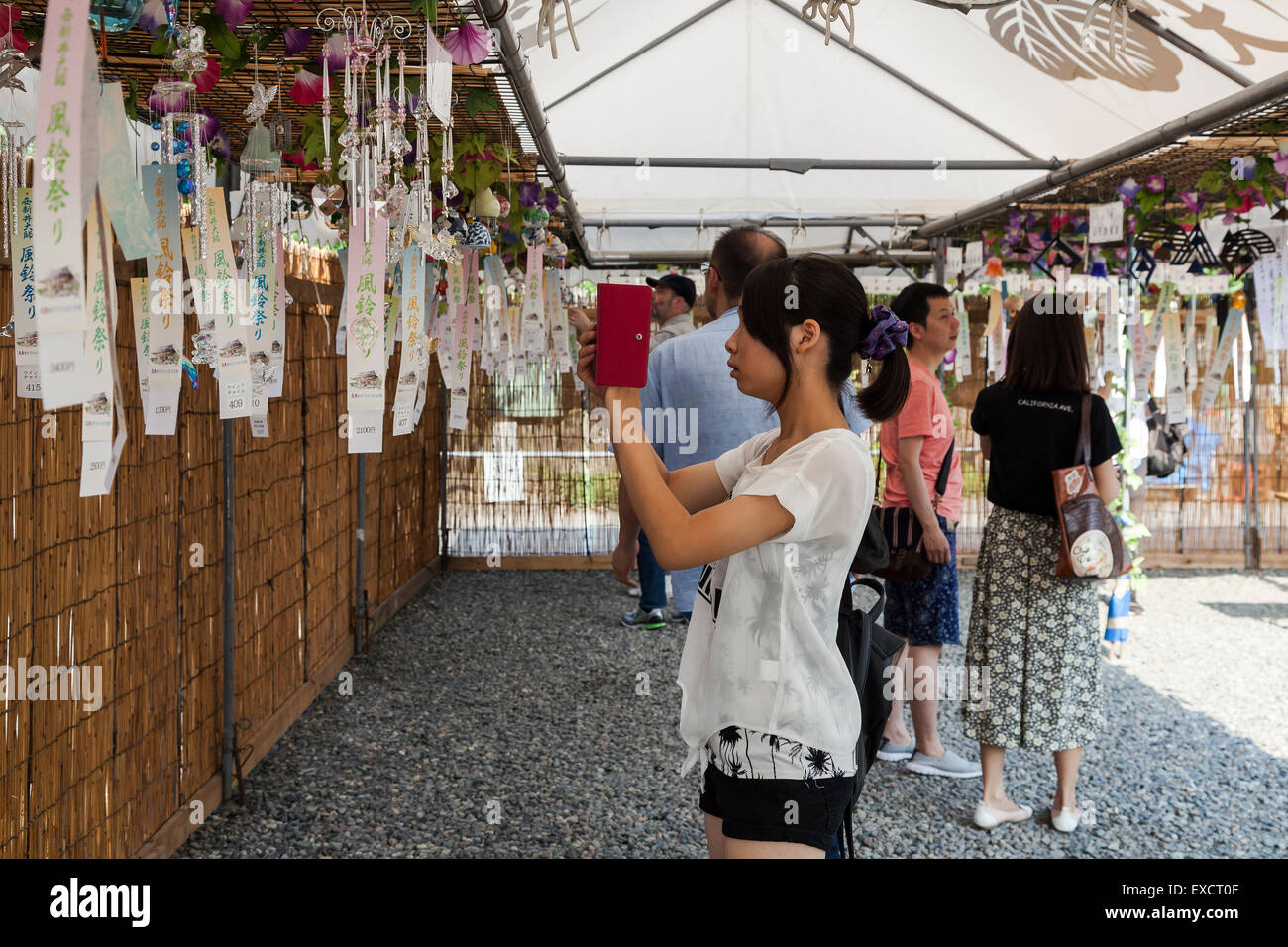 Visitors look at Japanese wind chimes (Fuurin) made of glass during the ...