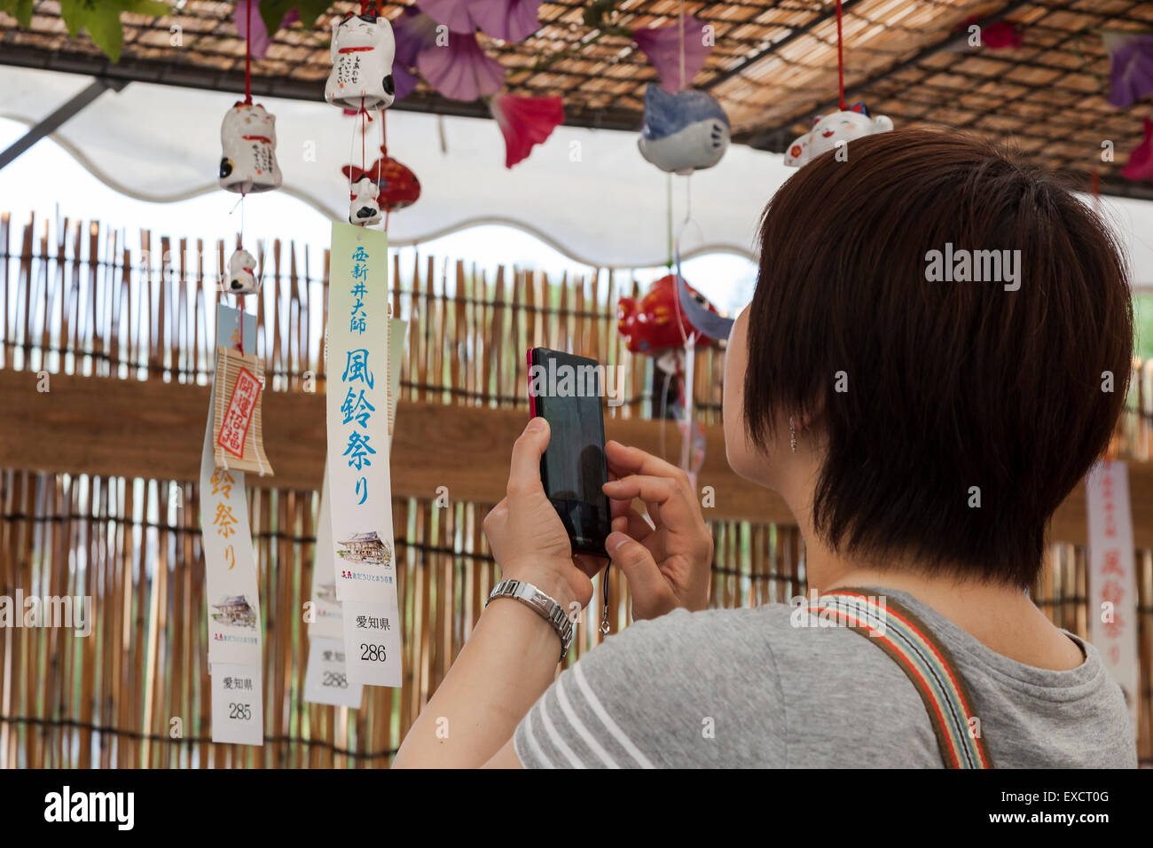 A visitors takes a picture of Japanese wind chimes (Fuurin) made of ...
