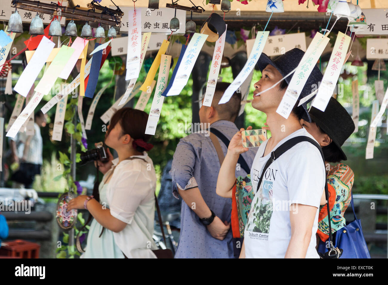 Visitors look at Japanese wind chimes (Fuurin) made of glass during the ...