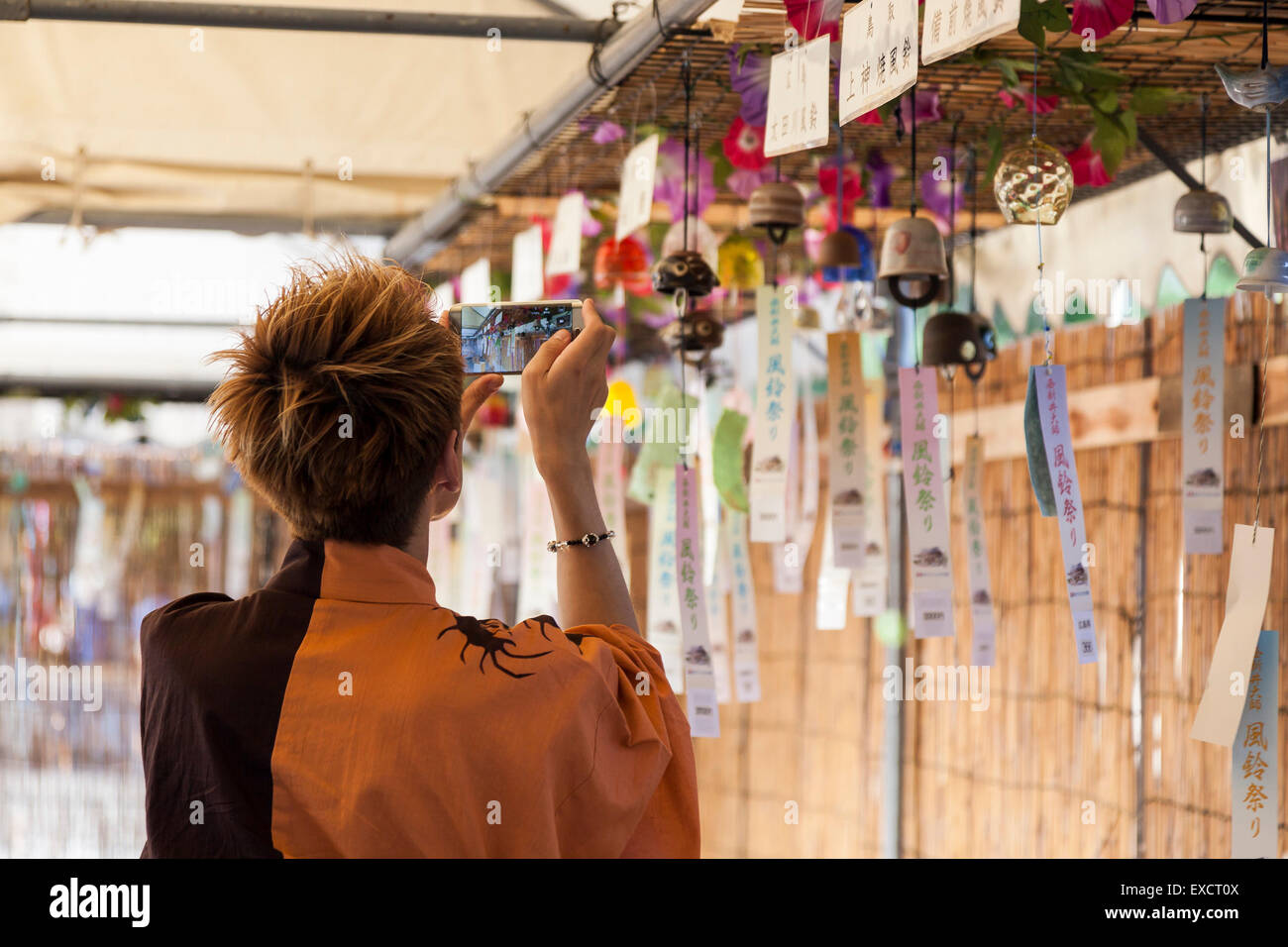 A visitors takes a picture of Japanese wind chimes (Fuurin) made of ...