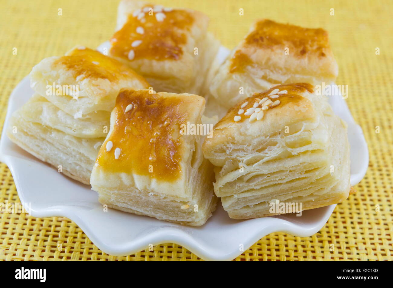 Homebaked puff pastry with sesame on a yellow background Stock Photo ...