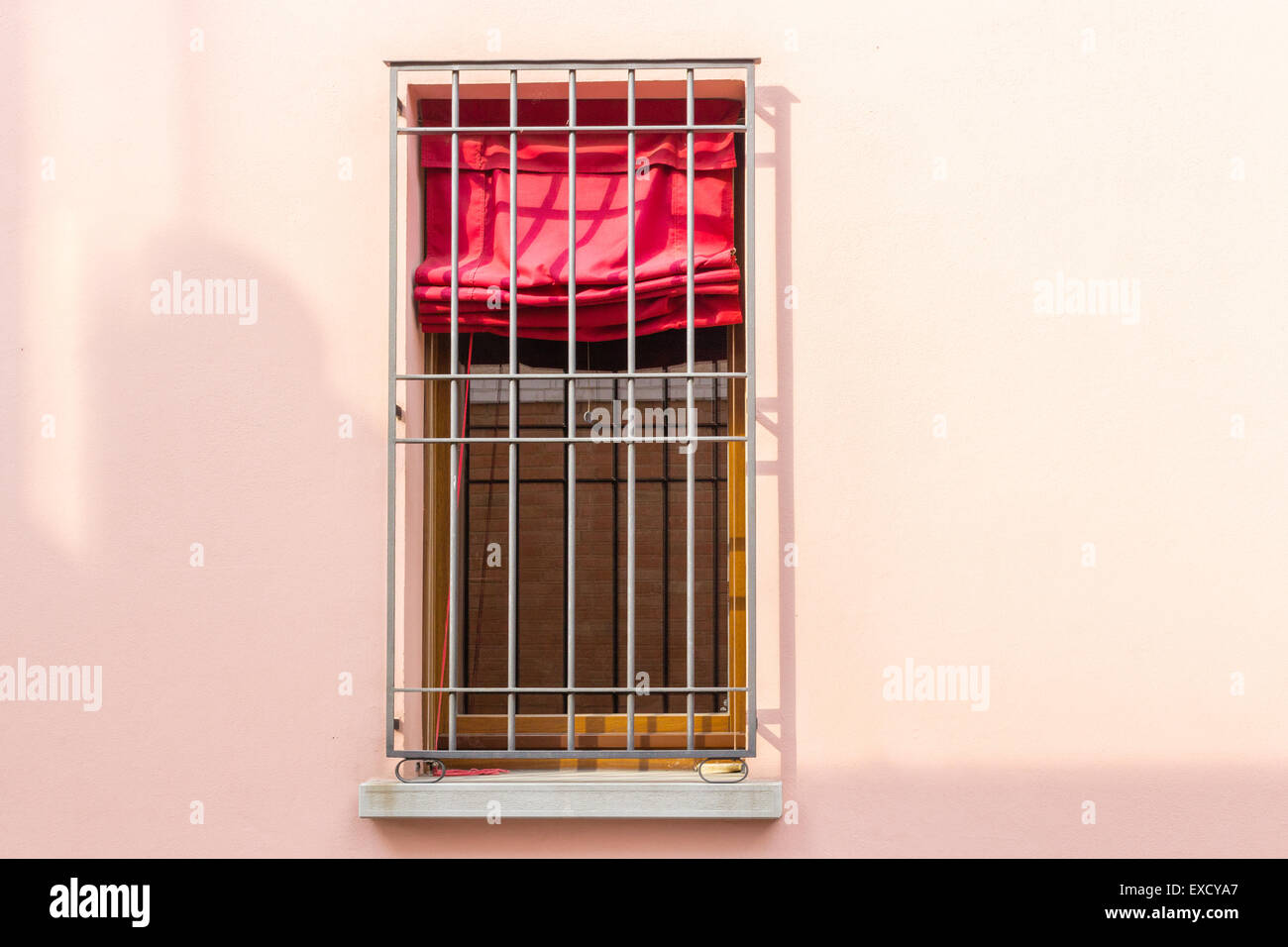 Iron grating window with red curtain Stock Photo - Alamy