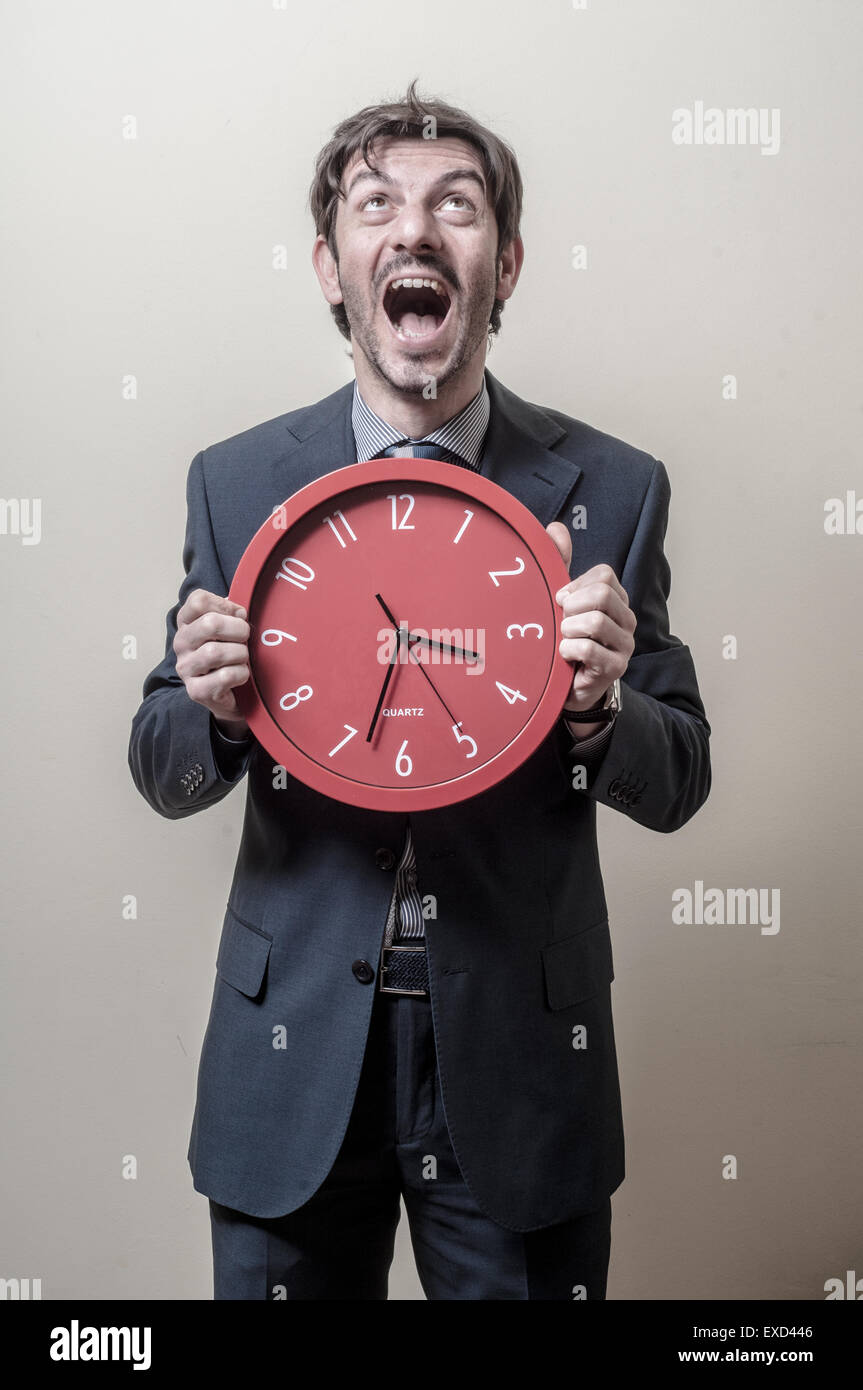 businessman with clock screaming on gray background Stock Photo - Alamy