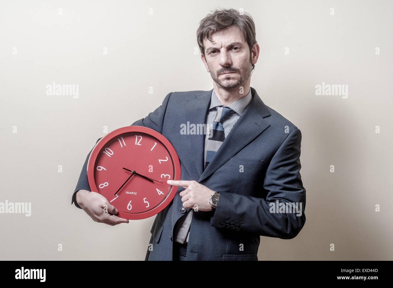 businessman pointing clock on gray background Stock Photo - Alamy