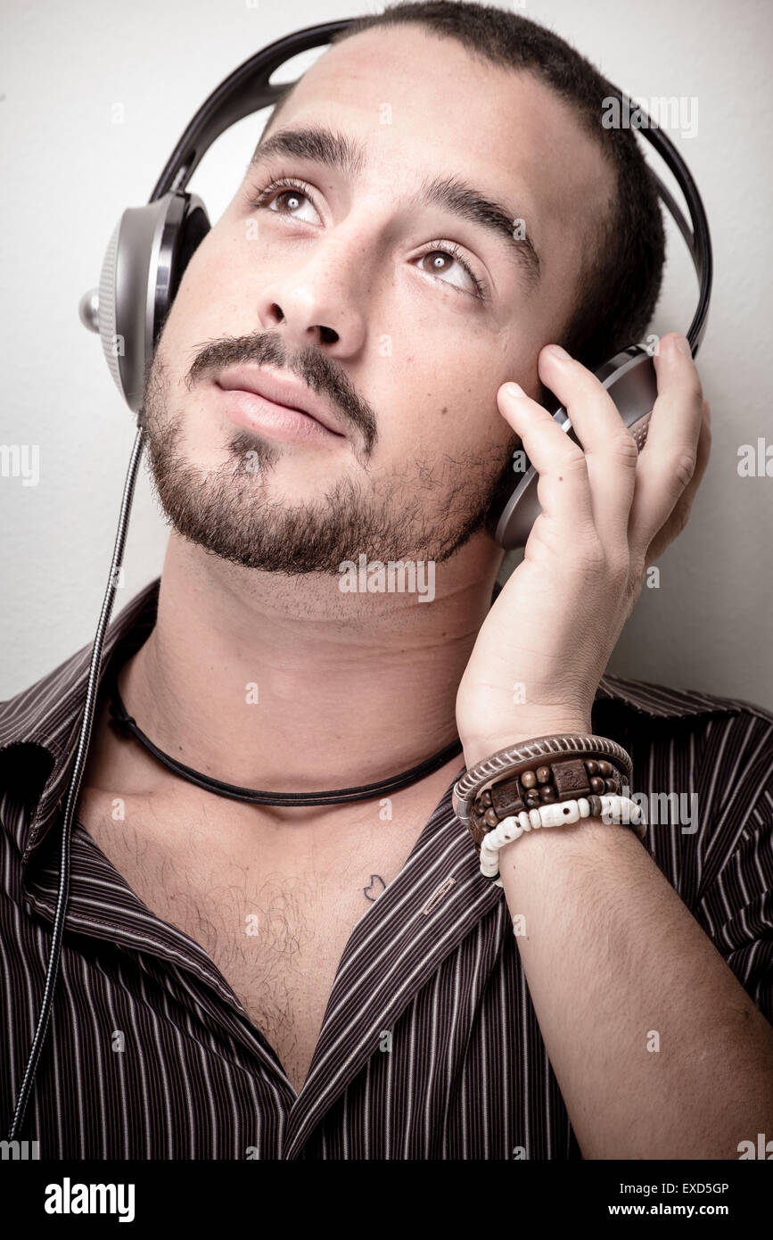 young stylish man listening to music on gray background Stock Photo - Alamy