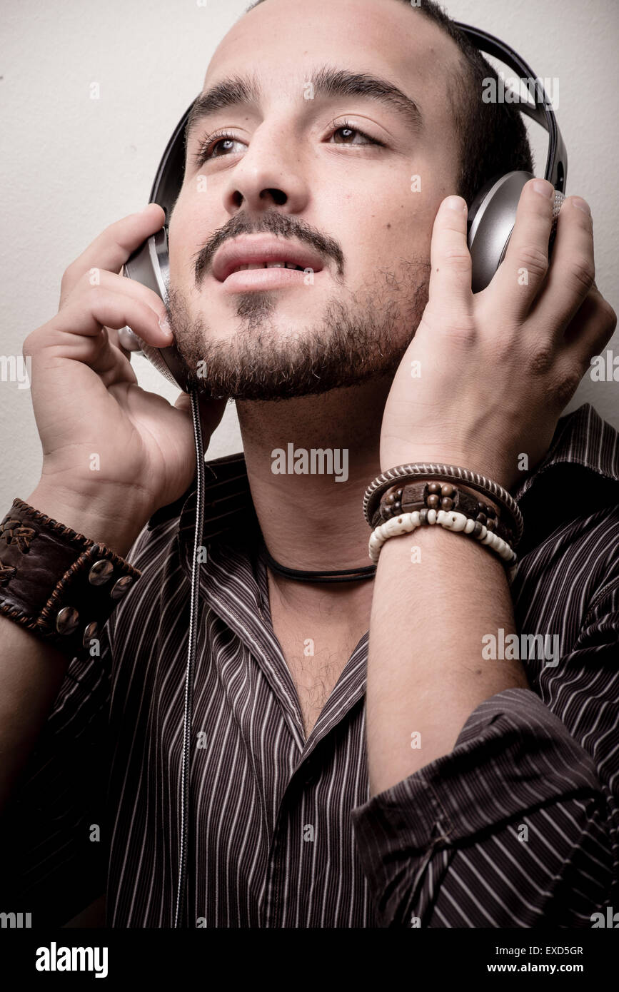young stylish man listening to music on gray background Stock Photo - Alamy