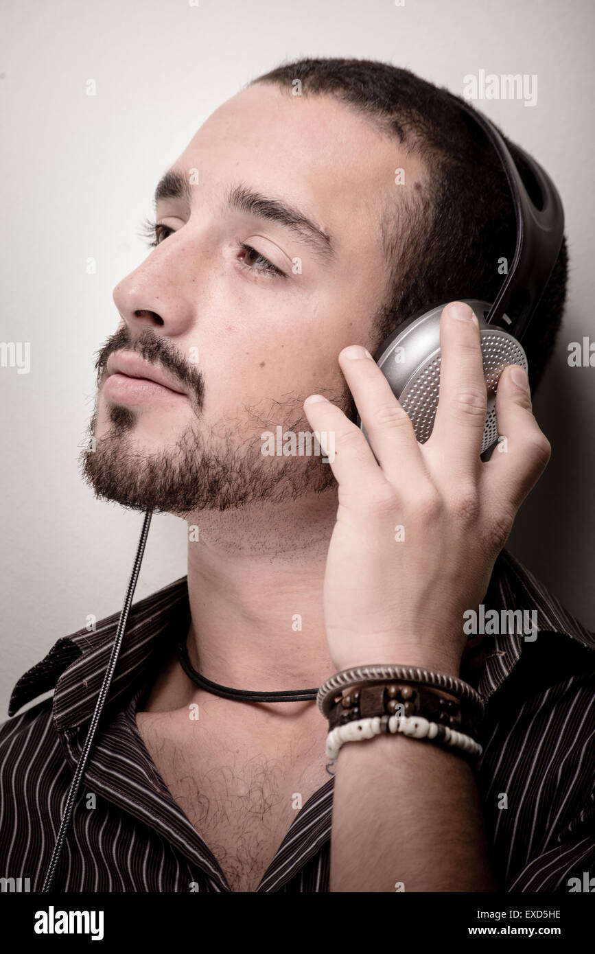 young stylish man listening to music on gray background Stock Photo - Alamy