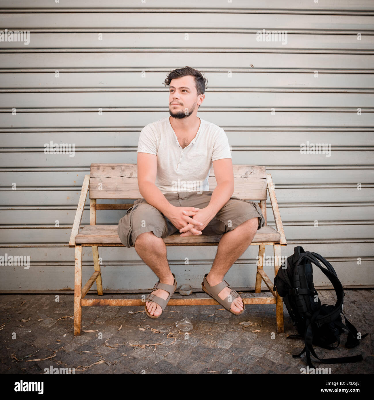 stylish man sitting on a bench in the street Stock Photo - Alamy