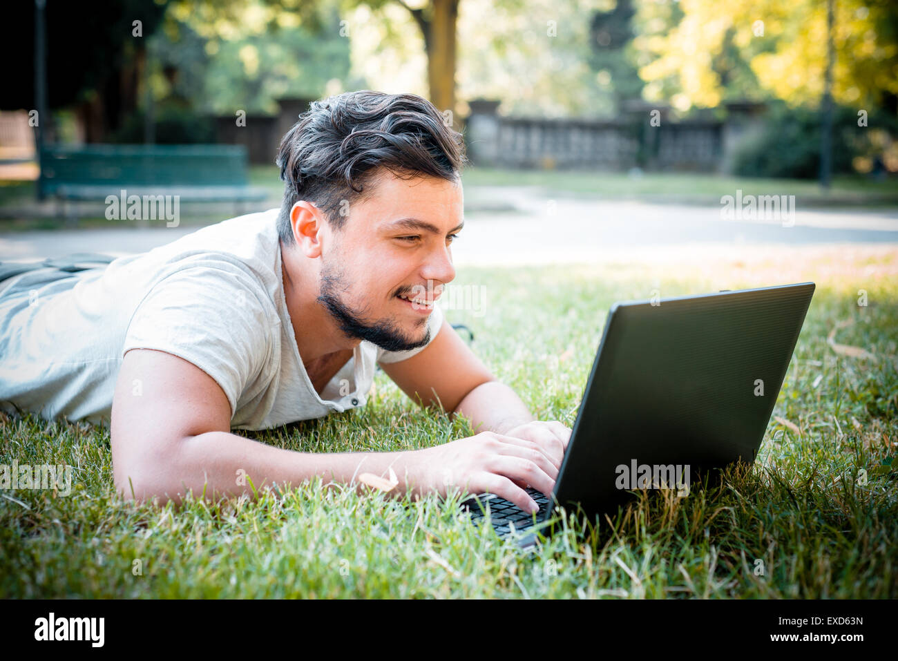 young stylish man using notebook at the park Stock Photo - Alamy