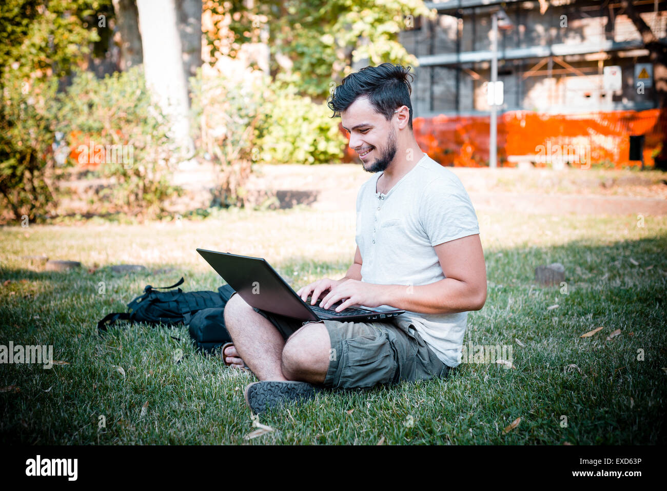 young stylish man using notebook at the park Stock Photo - Alamy