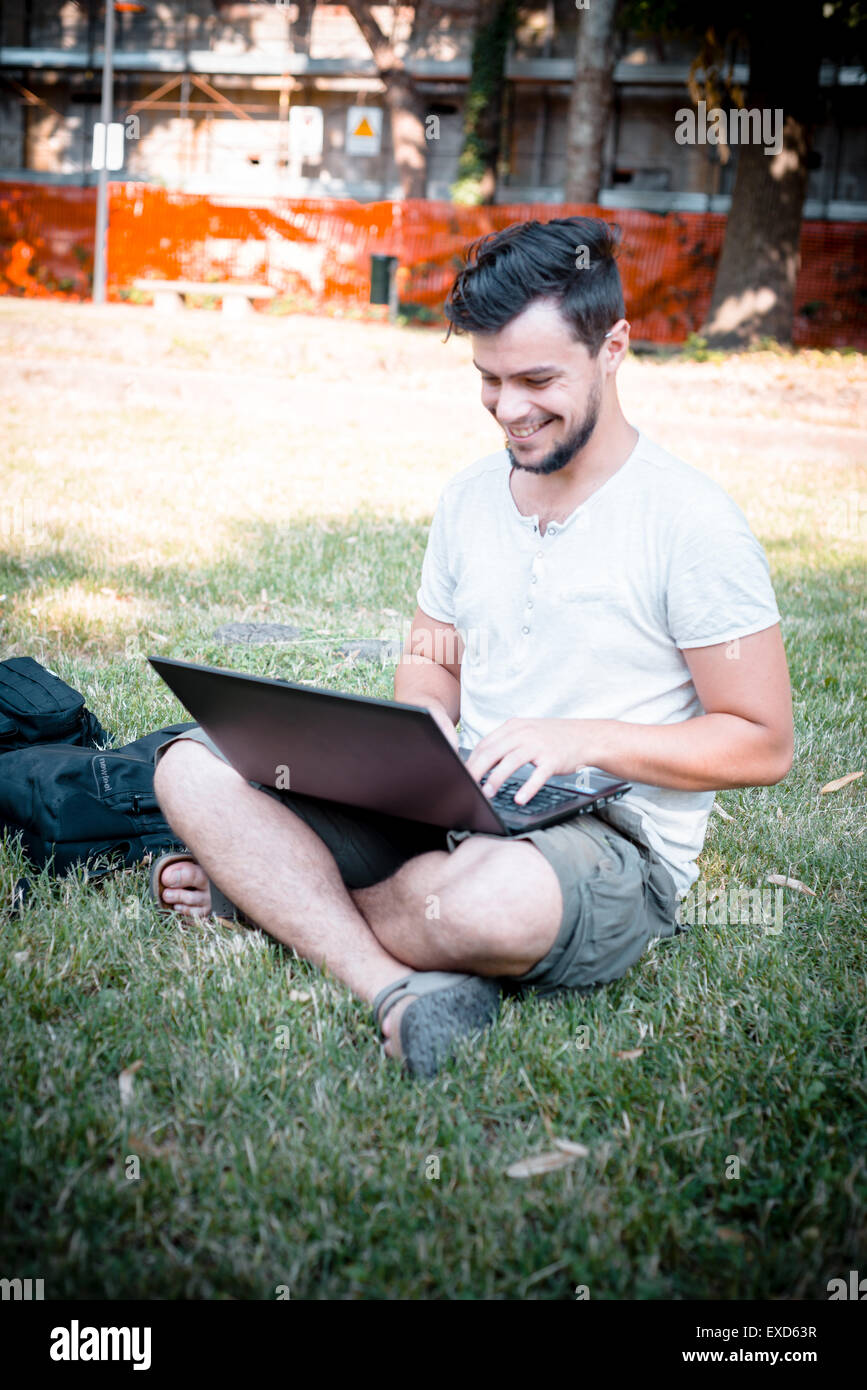 young stylish man using notebook at the park Stock Photo - Alamy