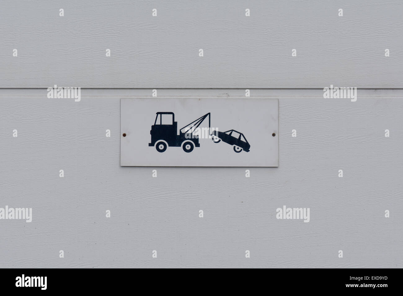 Tow truck pulling car sign on garage wall Stock Photo - Alamy