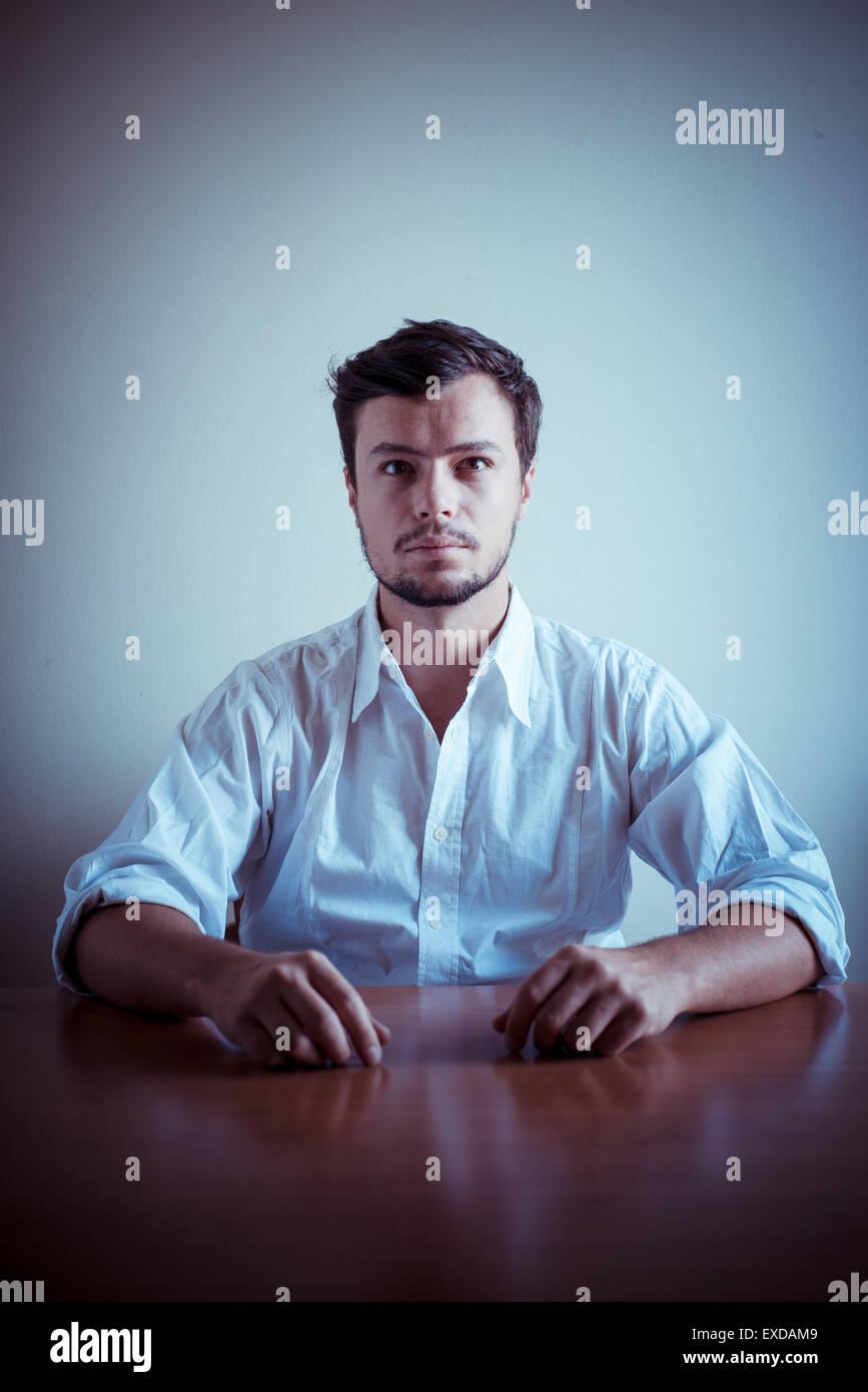 young stylish man with white shirt behind a table Stock Photo - Alamy