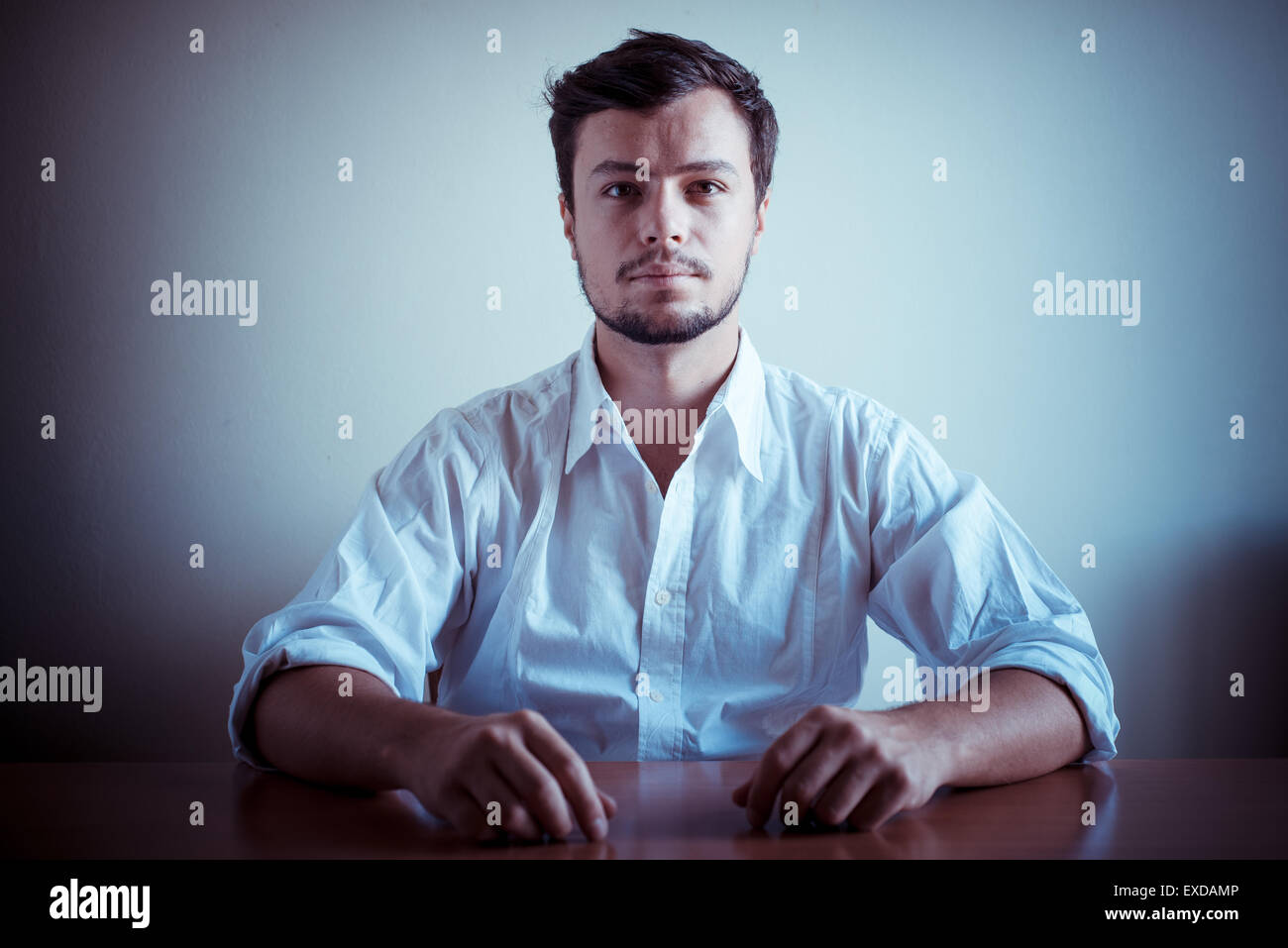 young stylish man with white shirt behind a table Stock Photo - Alamy
