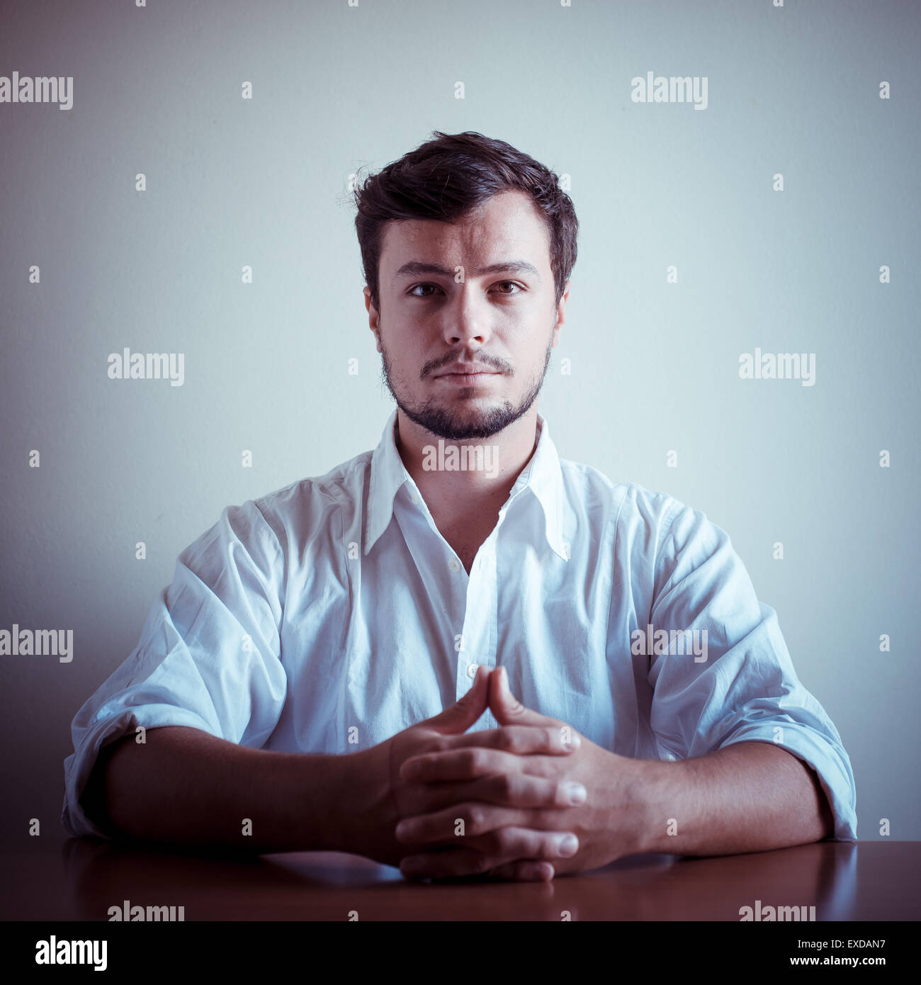 young stylish man with white shirt behind a table Stock Photo - Alamy