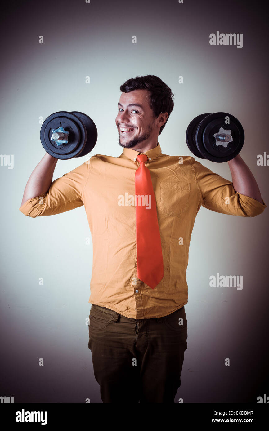funny crazy young man weightlifting on gray background Stock Photo - Alamy