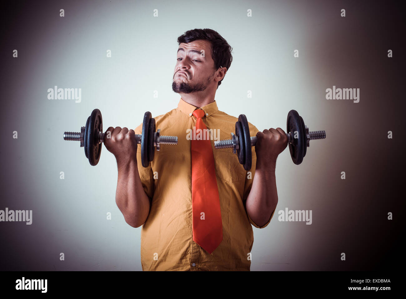 funny crazy young man weightlifting on gray background Stock Photo - Alamy