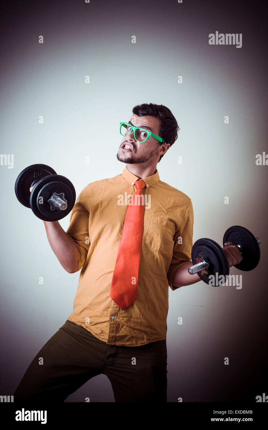 funny crazy young man weightlifting on gray background Stock Photo - Alamy