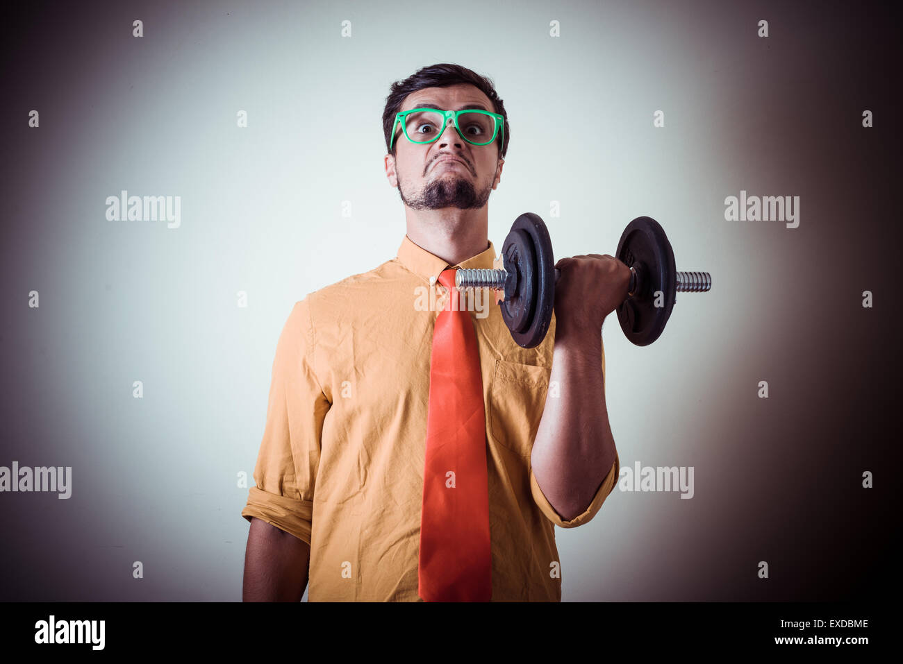 funny crazy young man weightlifting on gray background Stock Photo - Alamy