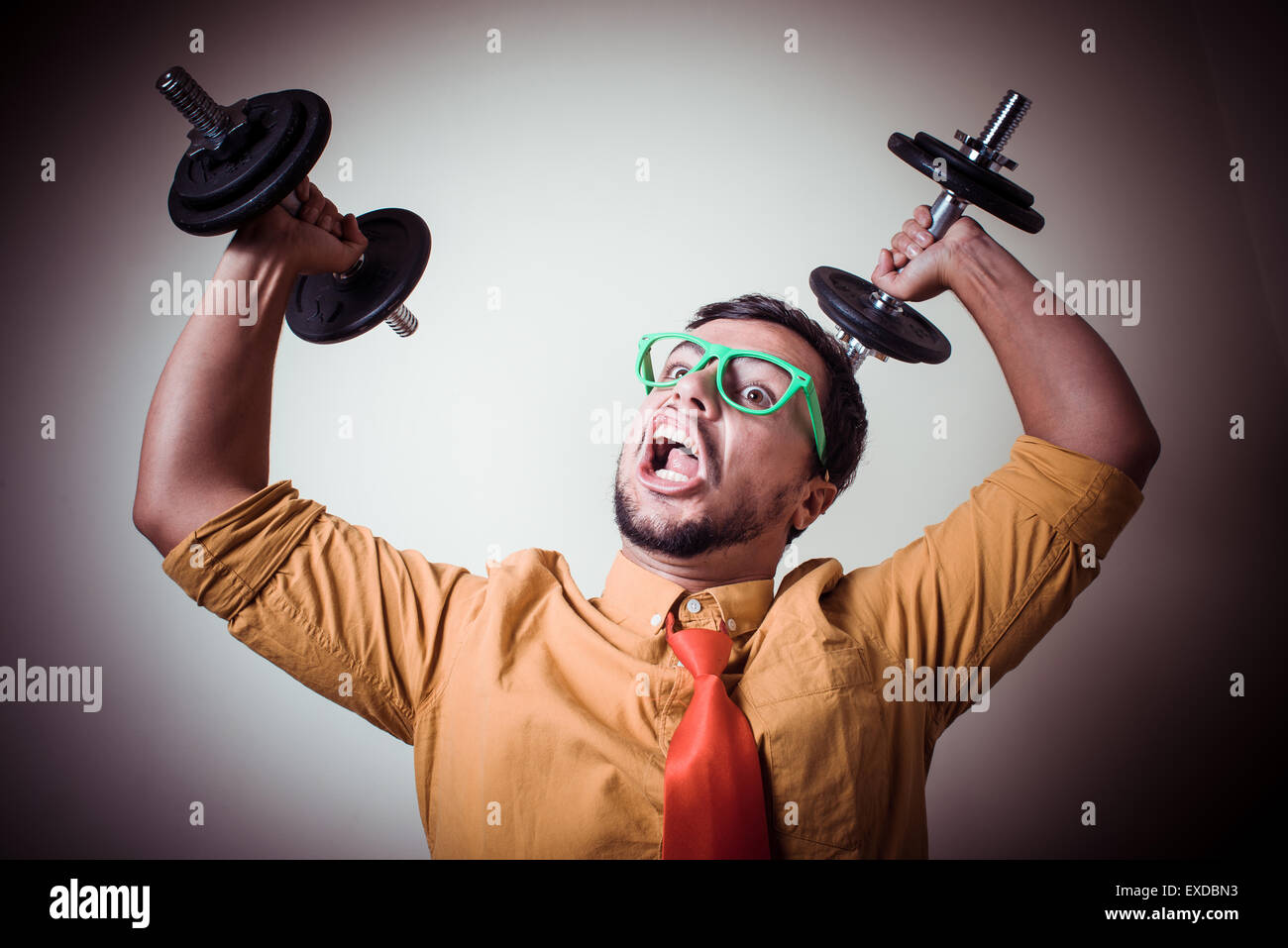 funny crazy young man weightlifting on gray background Stock Photo - Alamy