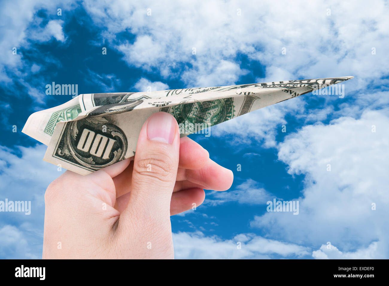 Flying paper plane with dollar banknote holding in hand, on blue cloudy ...