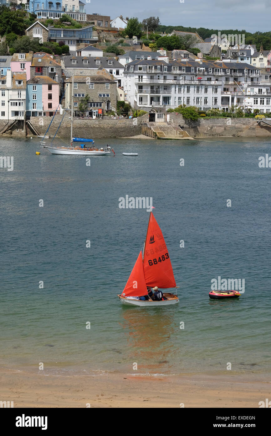 Salcombe, Devon, UK. Sailing on the river - small yacht with red sail ...