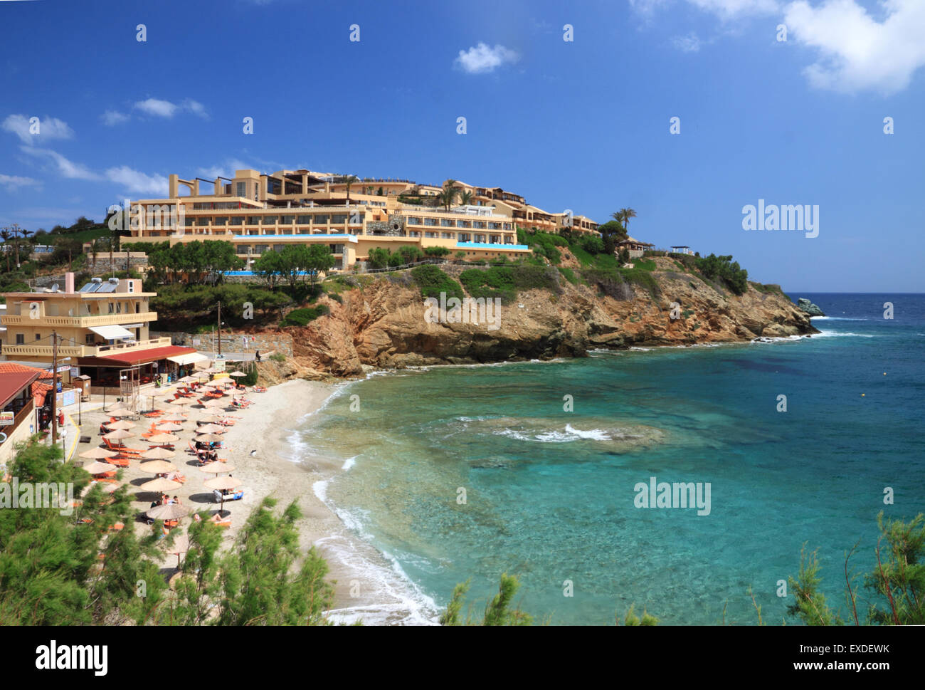 A modern resort hotel overlooking a Mediterranean beach with turquoise ...