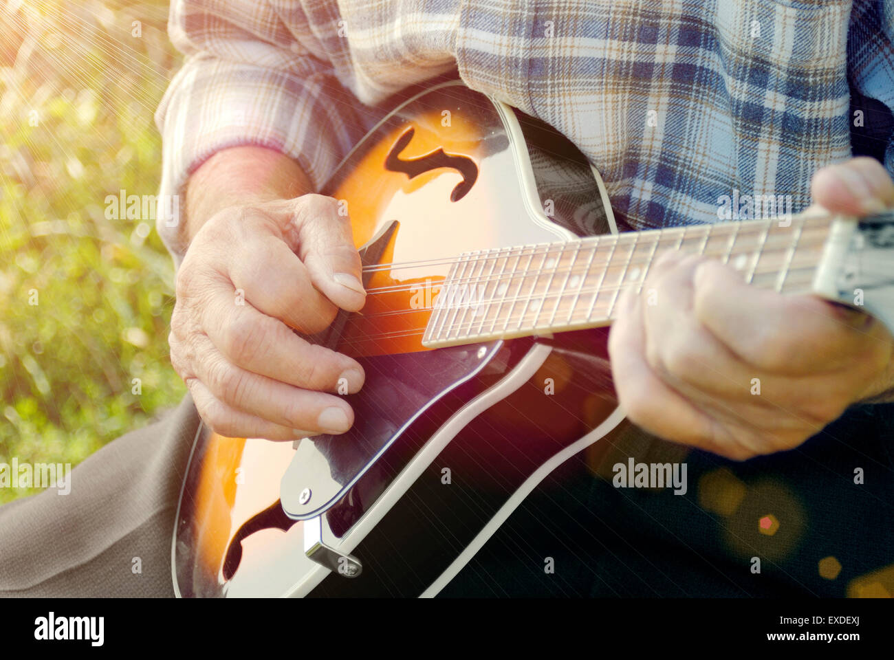 Senior man playing mandolin outside on the green background Stock Photo ...