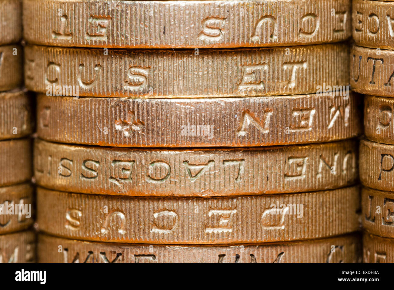 Columns of British £1, one pound, coins stacked up showing lettering on ...