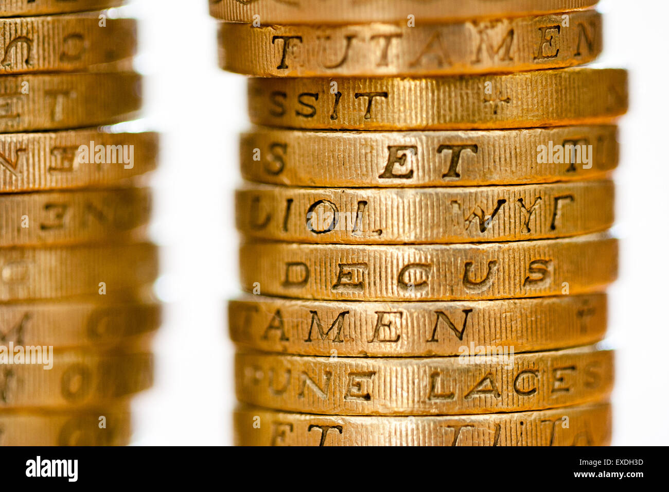 Columns of British £1, one pound, coins stacked up showing lettering on ...
