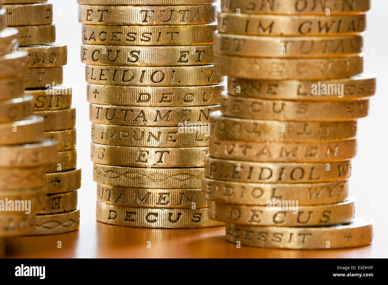 Columns of British £1, one pound, coins stacked up showing lettering on ...