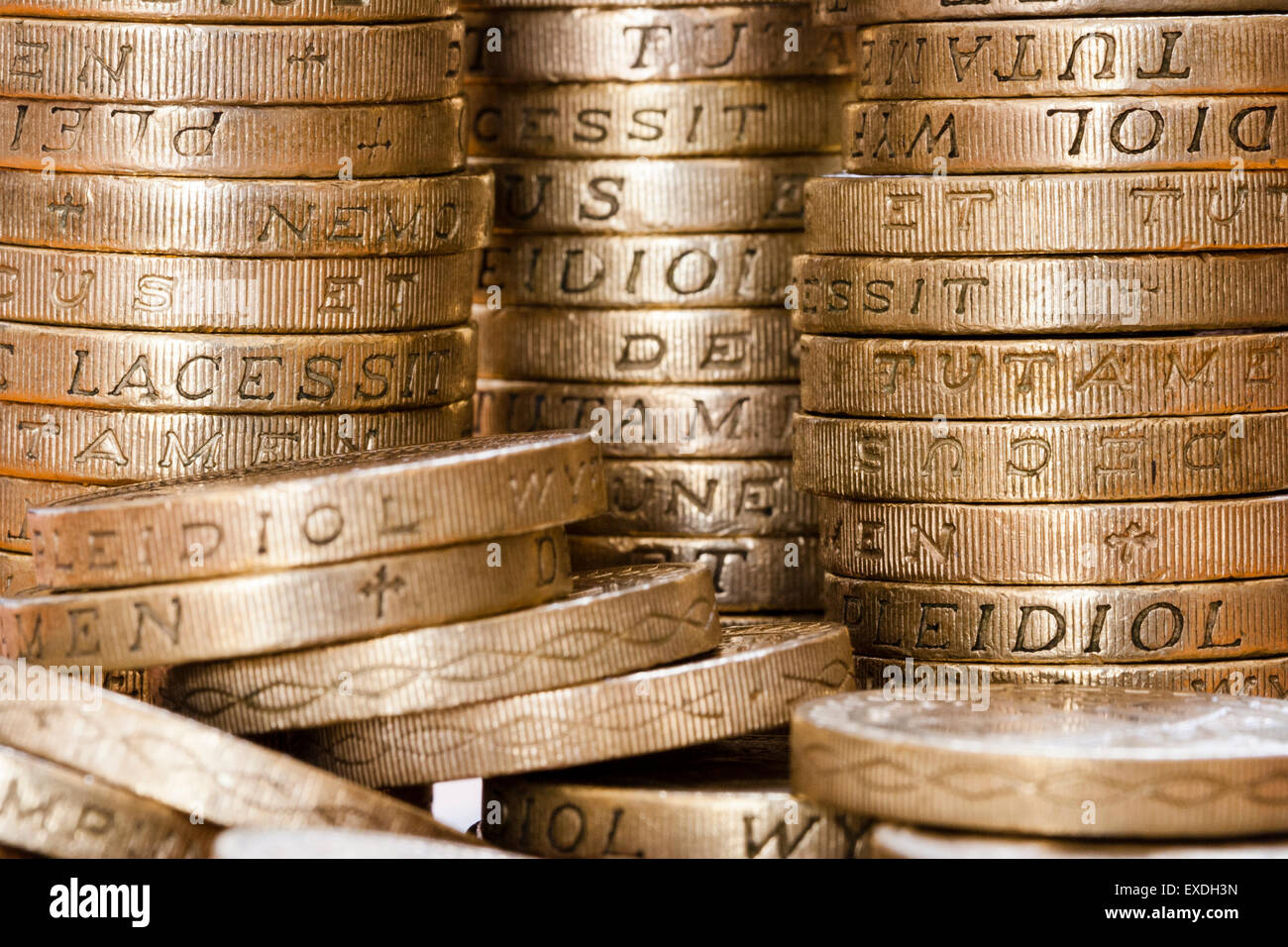 Columns of British £1, one pound, coins stacked up showing lettering on ...