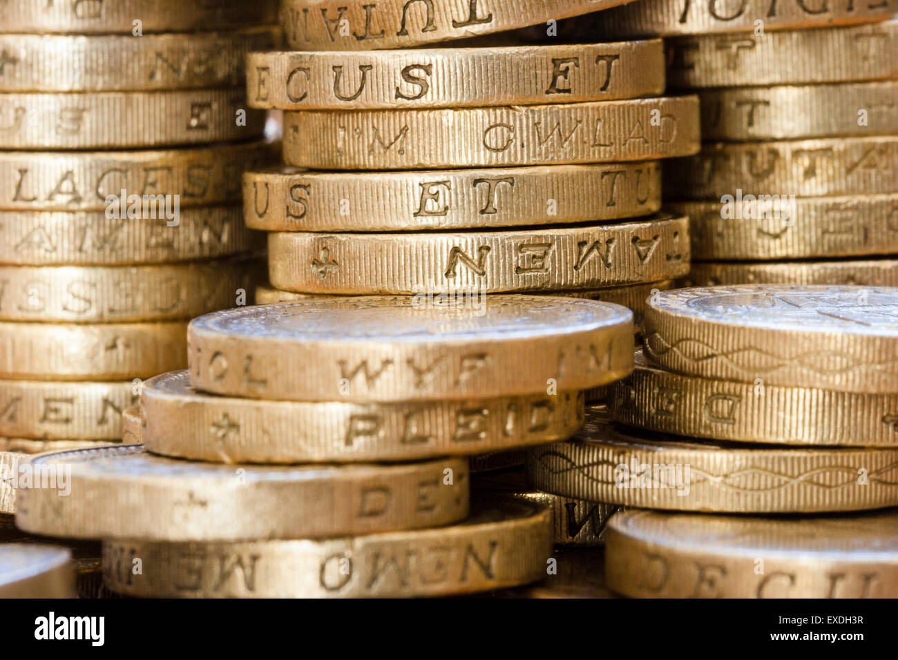 Columns of British £1, one pound, coins stacked up showing lettering on ...