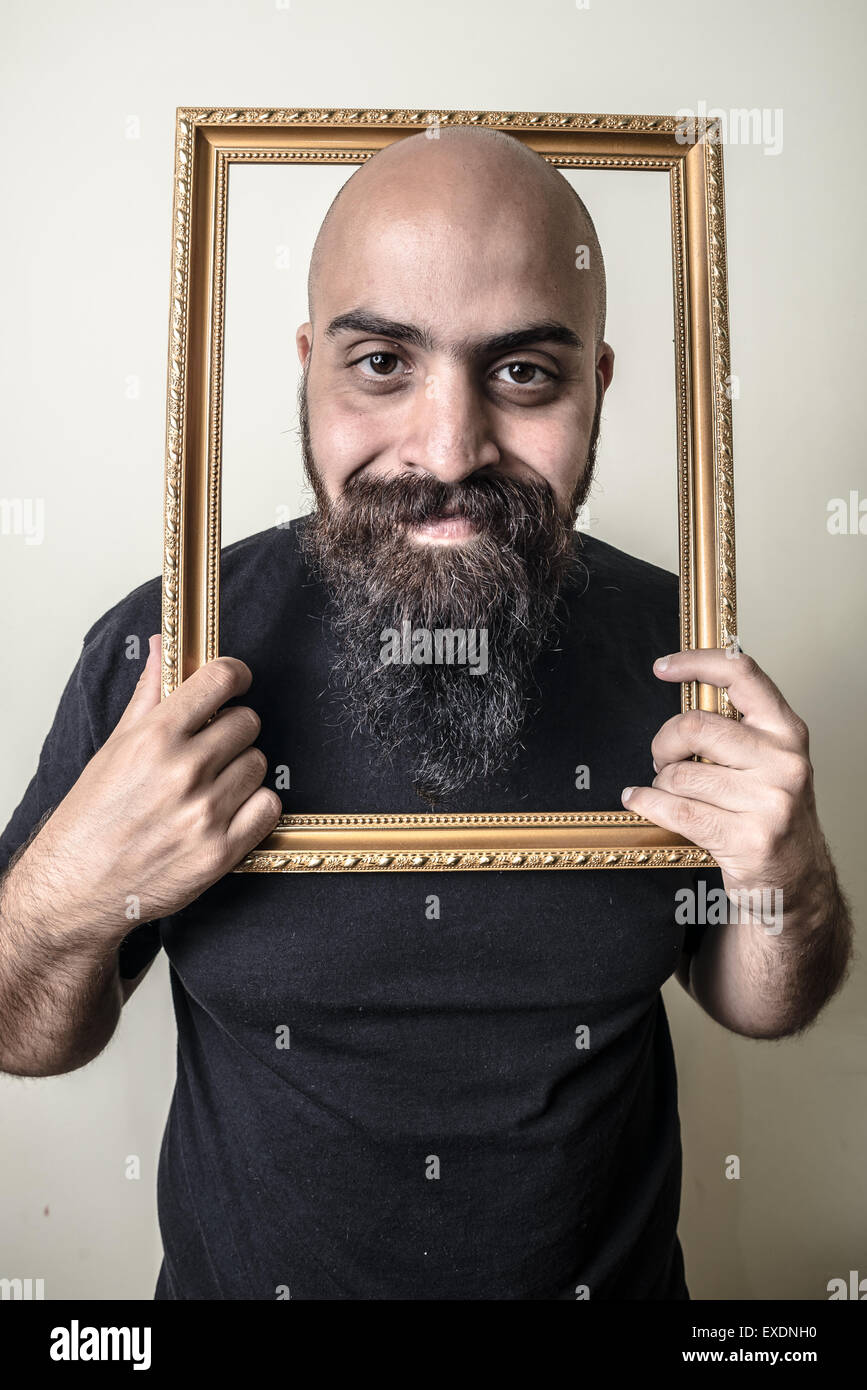funny bearded man with golden frame on gray background Stock Photo - Alamy