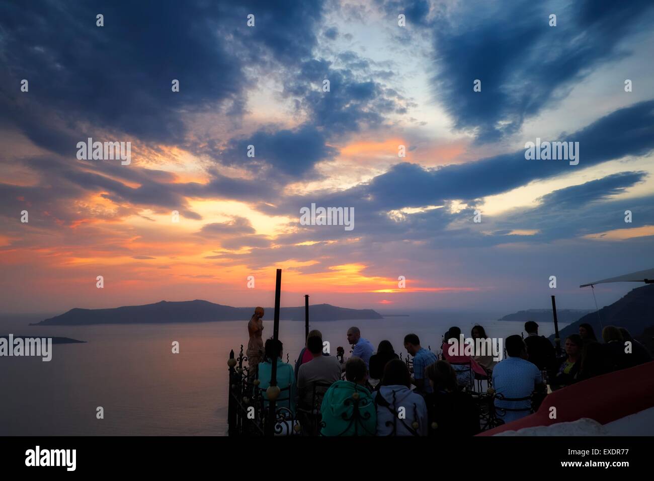 People eating and drinking at an outdoor restaurant during sunset in ...
