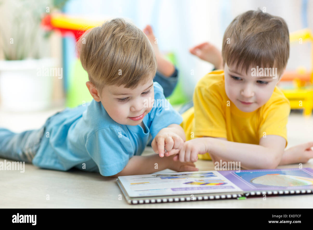 Two boys reading a book together Stock Photo - Alamy