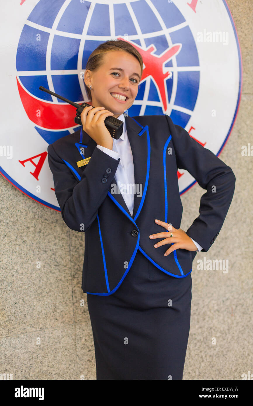 Beautiful smiling stewardess in a uniform with radio Stock Photo - Alamy